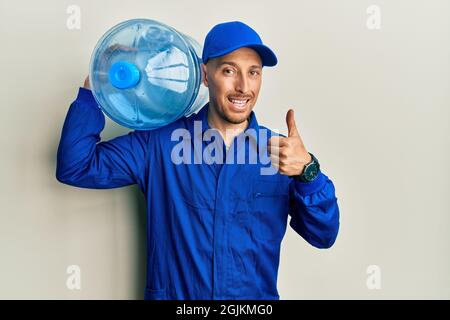Hispanic service man holding a gallon bottle of water for delivery ...