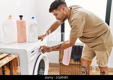 Young hispanic man smilig confident ironing at laundry room Stock Photo ...