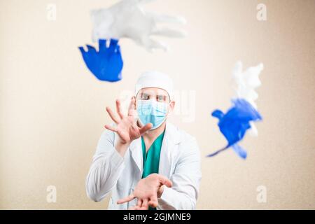 The doctor plays and throws up his gloves. On a light background Stock ...