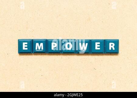 Tile alphabet letter with word empower in red color rack on wood ...