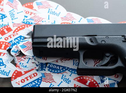 Concept for election violence with handgun placed on many torn and ...