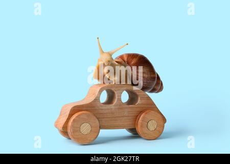 Snail and figure of car on color background, closeup Stock Photo - Alamy