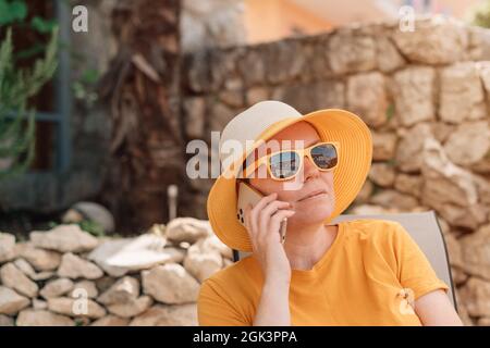 Digital nomad, woman in the hat, a business woman with a laptop sits on ...