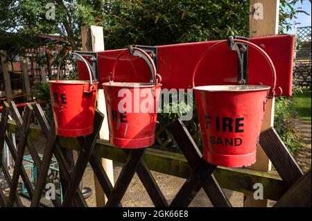 Red fire buckets filled with sand Stock Photo - Alamy