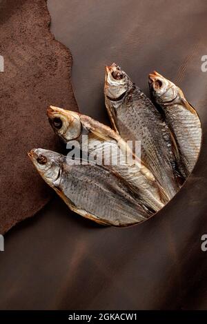 Salted air-dried roach peeking out of hole in brown leather flap Stock ...