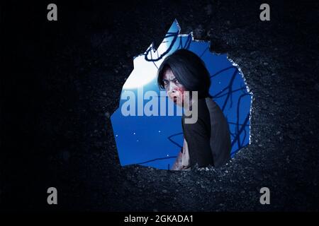Wall hole with a scary zombie standing with night scene background ...