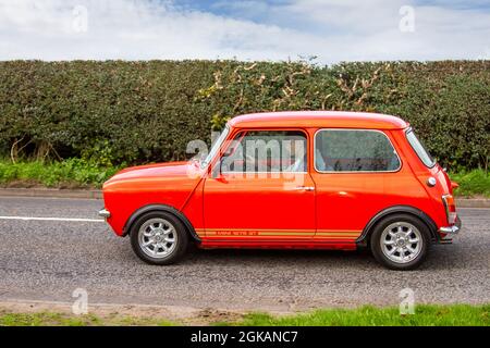 Side view of a classic Mini 1275 GT car in red and showing the front ...