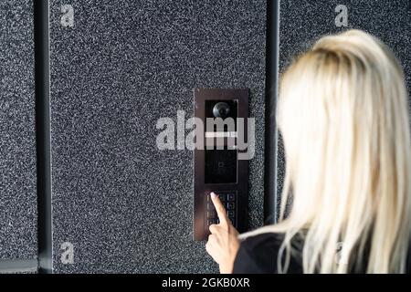 woman using intercom at building entrance Stock Photo - Alamy