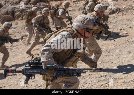 A Marine Corps machine gunner, Corporal Dwight Huskey, changes a tire ...