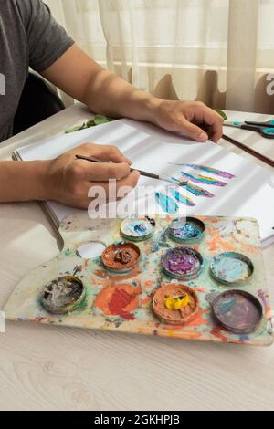 Creative tools desk with drawing painting supplies, colorful paints ...