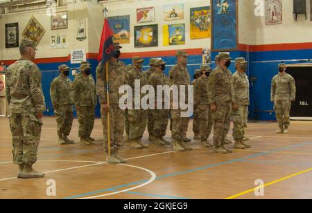 Soldiers and distinguished guests stand at attention in recognition of ...