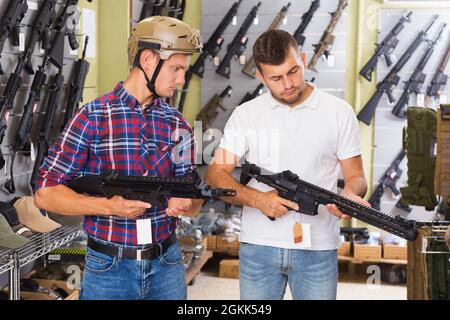 Friends choosing air-powered gun Stock Photo - Alamy
