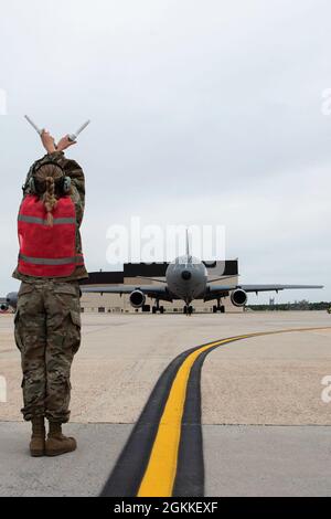 An airman assigned to 605th Maintenance Squadron marshals in a KC-46A ...