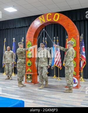 A newly promoted NCO walks through the NCO arch and crossed sabers ...