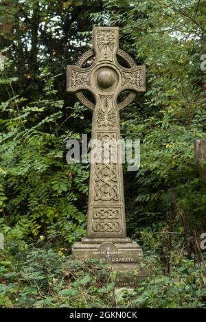 An ornately carved stone grave with ivy growing across it in the graveyard of St Andrews church ...