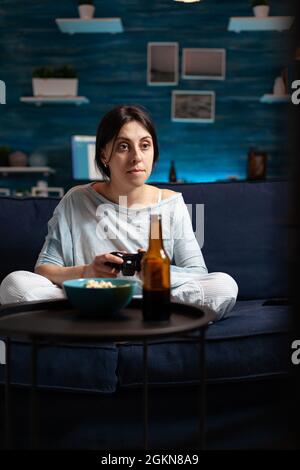 upset sport fan woman sitting with bowed head near tv remote controller ...