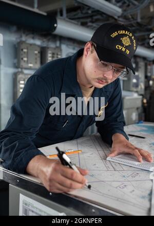 US Navy Quartermaster Seaman plots the ship's position before the ...