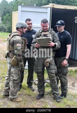 A safety looks on as Staff Sgt. Max Rees, 75th Training Division, gets ...