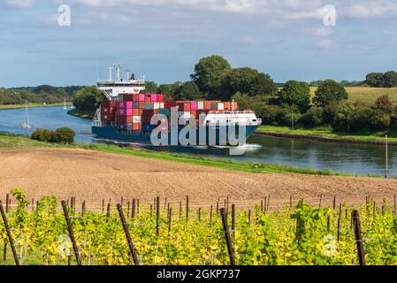 Ein Containerschiff im Nord-Ostsee-Kanal auf dem Weg zur Schleuse in Kiel-Holtenau in die Ostsee ...
