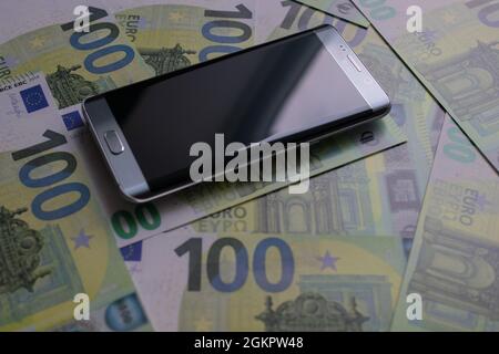 smartphone lies on 100 euro banknotes Stock Photo - Alamy
