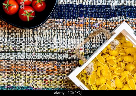 Pasta ingredients. Cherry tomatoes, pasta, fresh basil, spices on a ...
