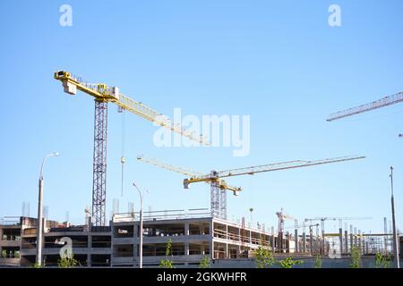 Construction cranes standing near multi storey buildings Stock Photo ...