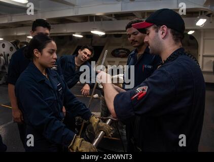 Damage Controlman 2nd Class Alexander Sarabia simulates a fire during a ...