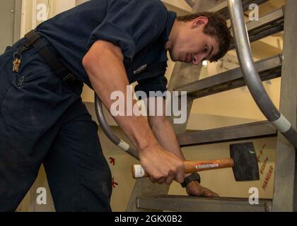 Aviation Boatswain's Mate performs maintenance on a catapult aboard USS ...