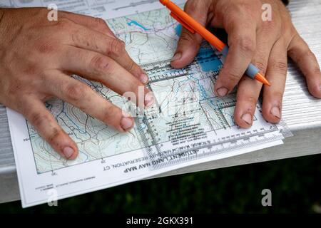 An Officer Candidate examines an area of a topographical line map using ...
