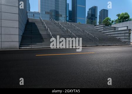 Asphalt road and wide steps leading to modern office buildings at an ...