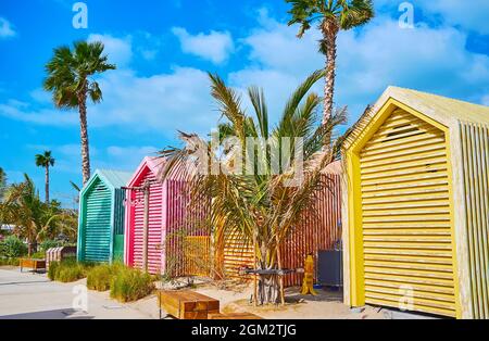 a line of colorful beach huts located in the sand dunes infront of a ...