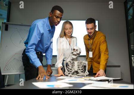 Businessman working with skeleton in office Stock Photo - Alamy