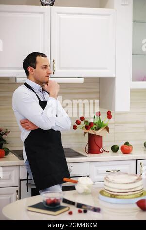 Master pastry chef in front of a desk. Cooking desserts at home. The ...