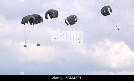 a line of parachute cargo glides down dropped from ZM401 an RAF Airbus ...