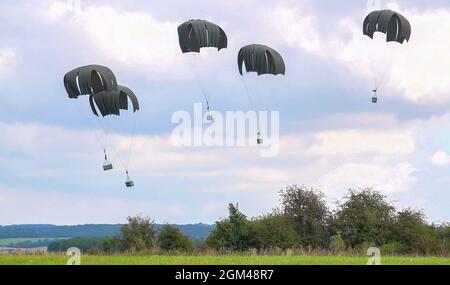 a line of parachute cargo glides down dropped from ZM401 an RAF Airbus ...