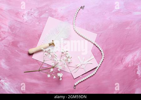 Blank card with envelope, flowers and necklace on light background ...