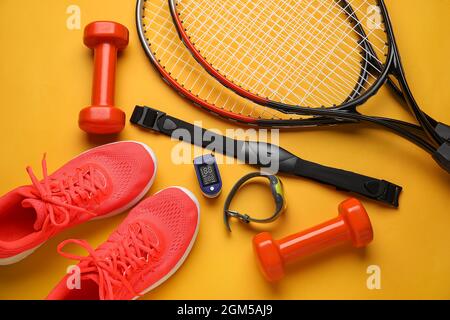 Sport top, fitness tracker, chest belt and sport equipment on light ...