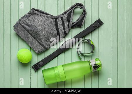 Sport top, fitness tracker, chest belt and sport equipment on light ...
