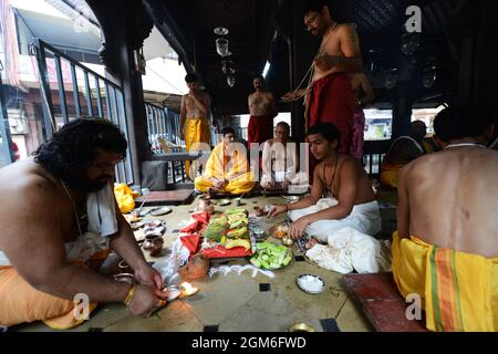 Marathi Hindu priests conducting a religious ceremony in a small temple ...
