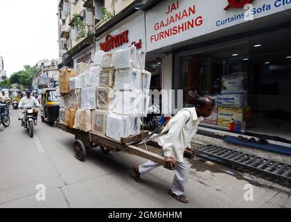man pulling a heavy loaded cart on the streets of Mumbai, India Stock ...