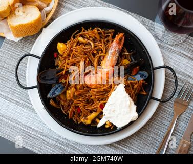 Valencian fideua with shrimps and mussels served with alioli on steel ...
