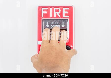 Hand of man pulling fire alarm switch on the white wall as background ...
