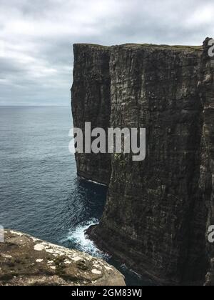 Black cliffs formation in the Atlantic ocean, Faroe Islands. Towering ...