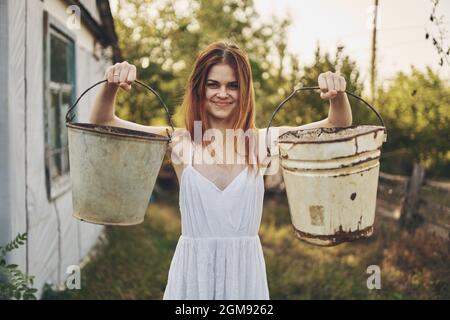 pretty woman with buckets in hand Sun freedom Stock Photo - Alamy