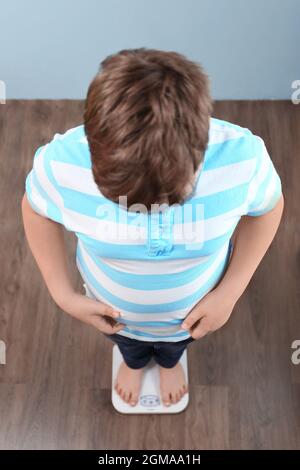 Overweight boy standing on scales against white background Stock Photo ...
