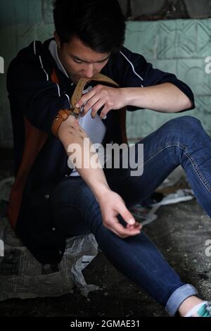 Asian teen uses drugs in the basement Stock Photo - Alamy