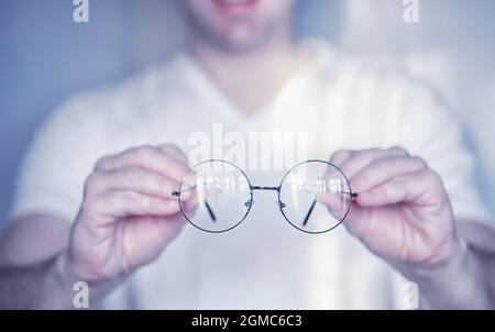 The concept of poor vision. Hold a contact lens and glasses in hand ...