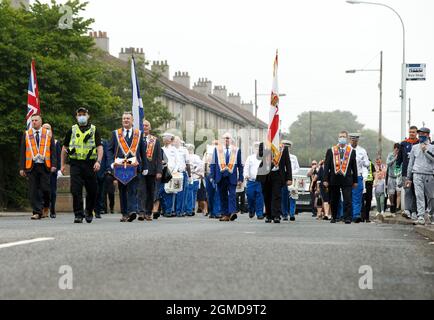 A silent Orange Order band marches through the streets of Easterhouse ...