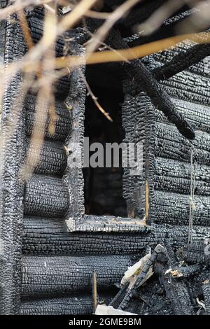 Wooden house after the fire. Coals on the logs. The ashes of the house ...