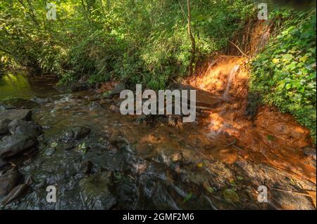 Red oxide staining in water course entering the Afon Goch Stock Photo ...